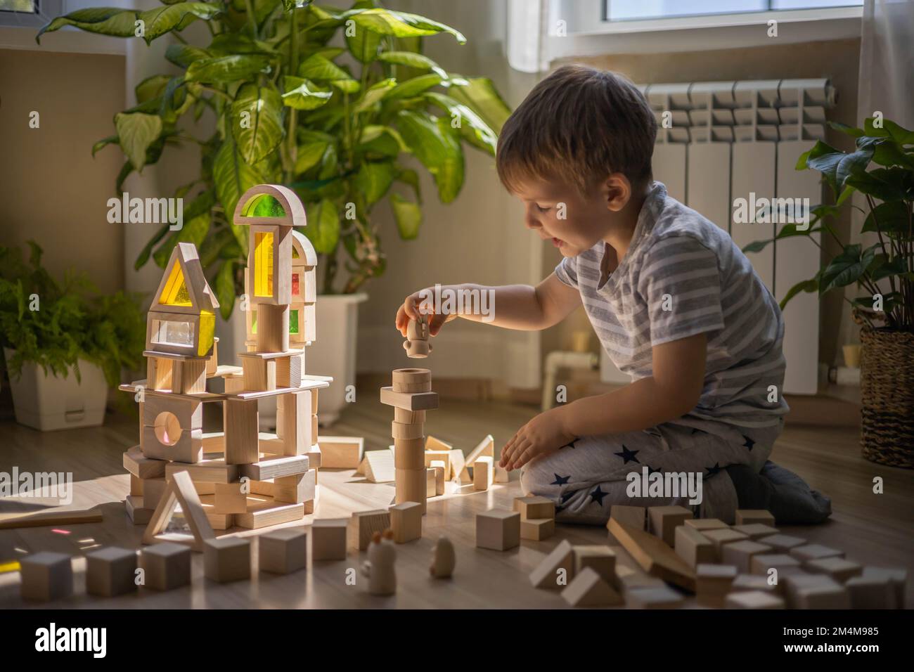 Cute baby boy building tower wooden bricks Montessori materials at ...
