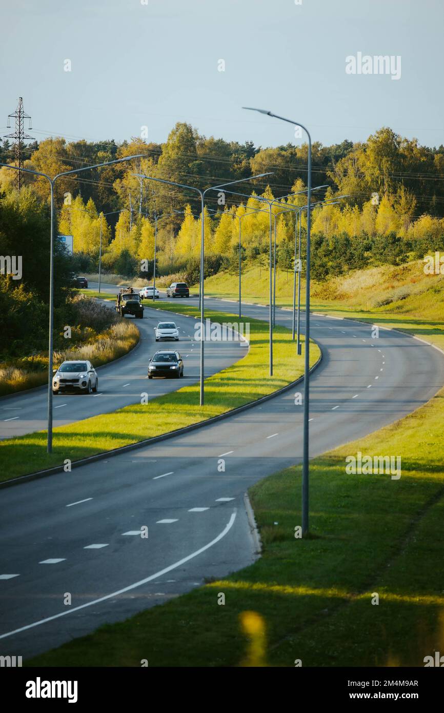 A vertical top view of cars driving along a highway road in the evening ...
