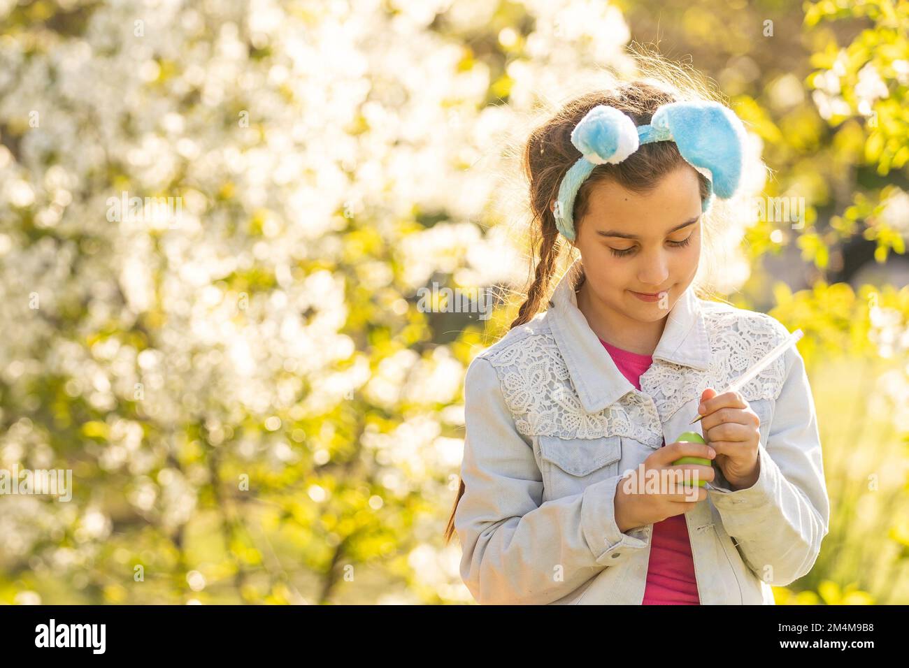 portrait of smiling young girl wearing traditional bunny ears headband ...