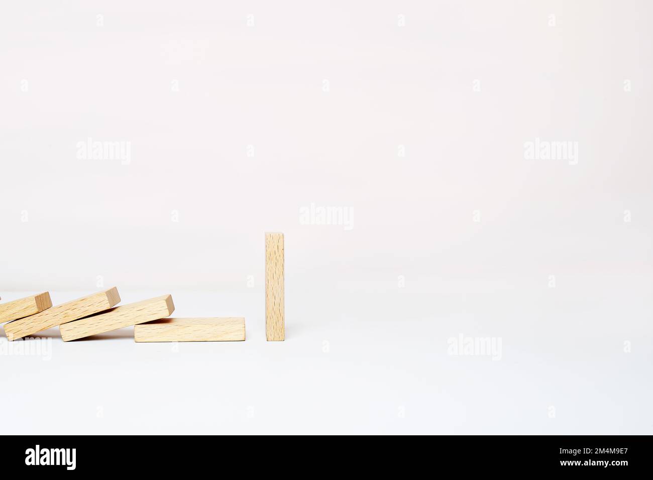 One domino stands, and other wooden dominoes fall in a row. Chain ...