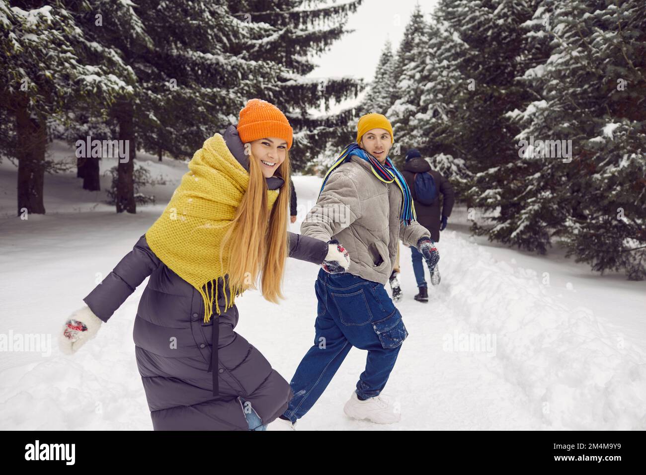 Positive excited young couple having fun running hand in hand through ...