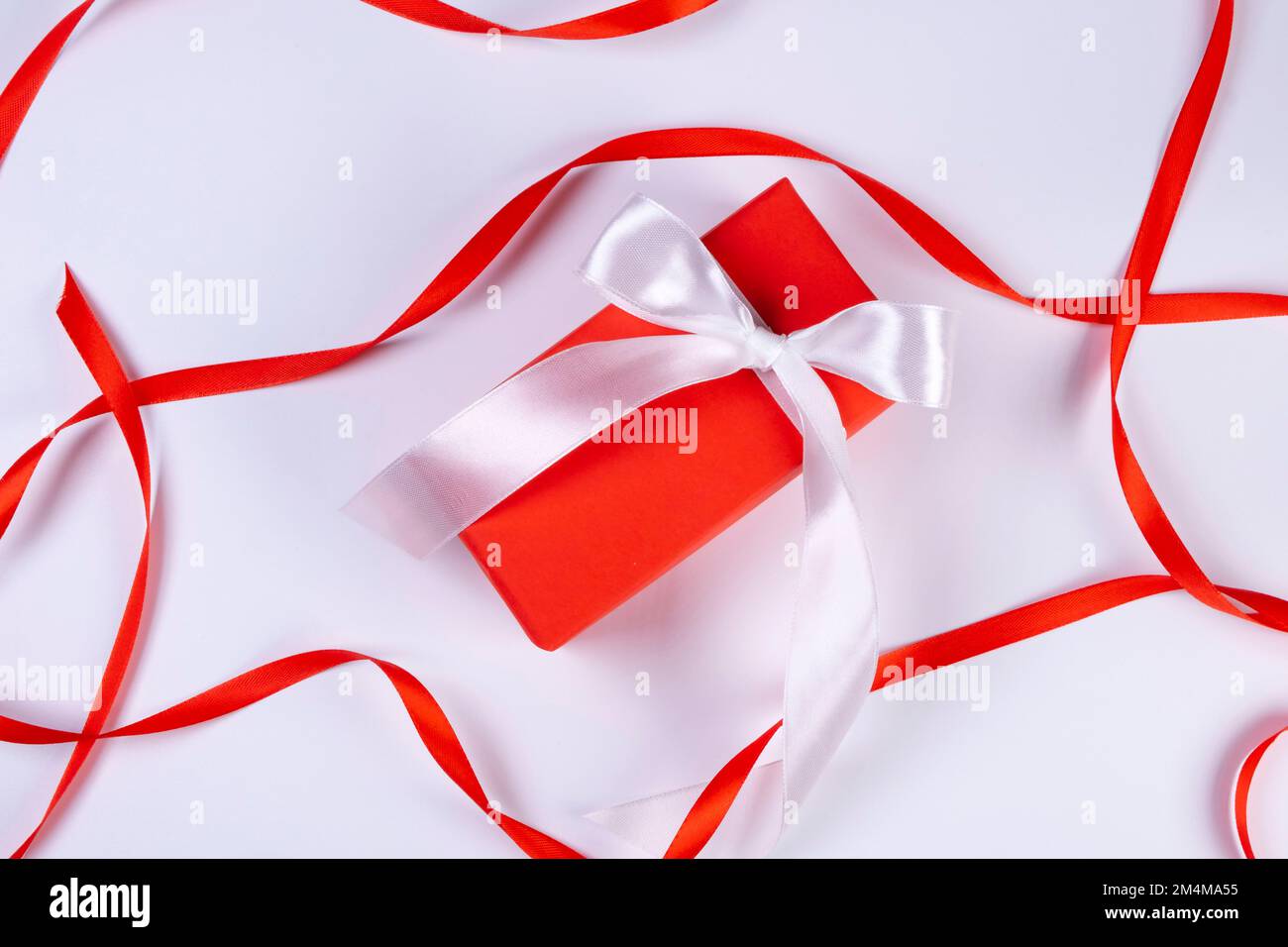 background with red festiv box with ribbons and bow on white background ...