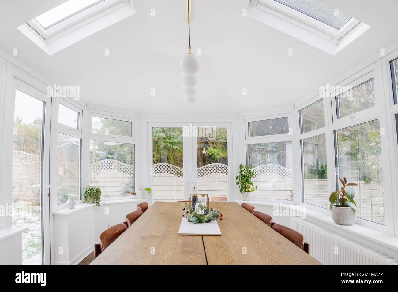 A minimalist, contemporary residential conservatory with dining table ...