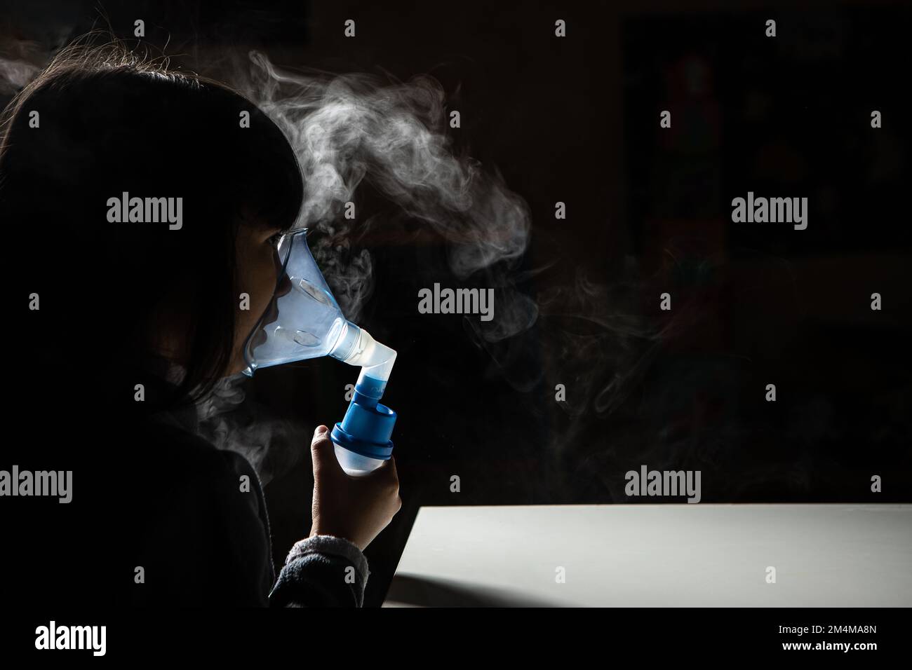 Vapors of the aerosol seen against the light on a dark background while ...