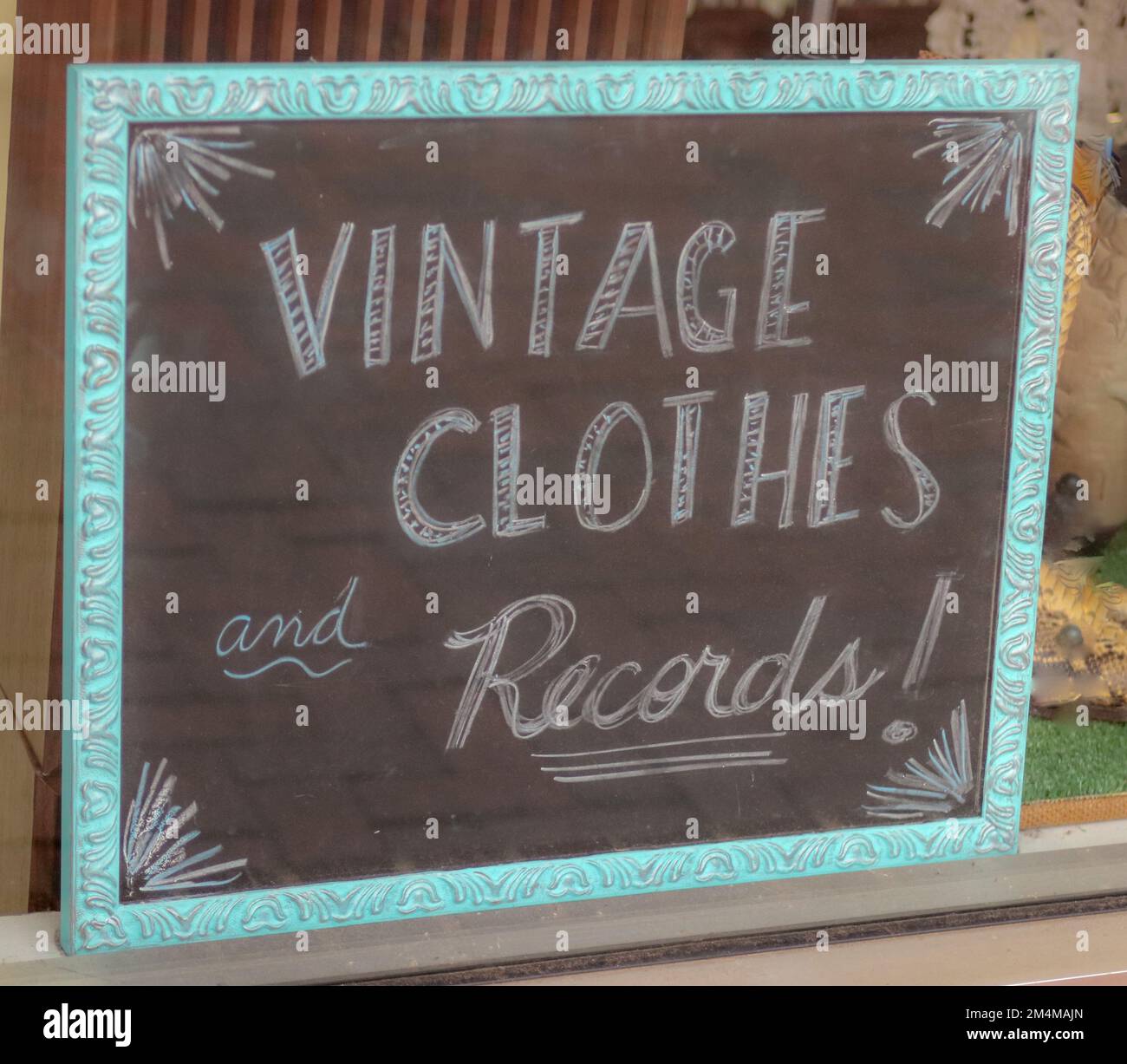 A sign for a vintage clothing and records store in a green frame Stock ...