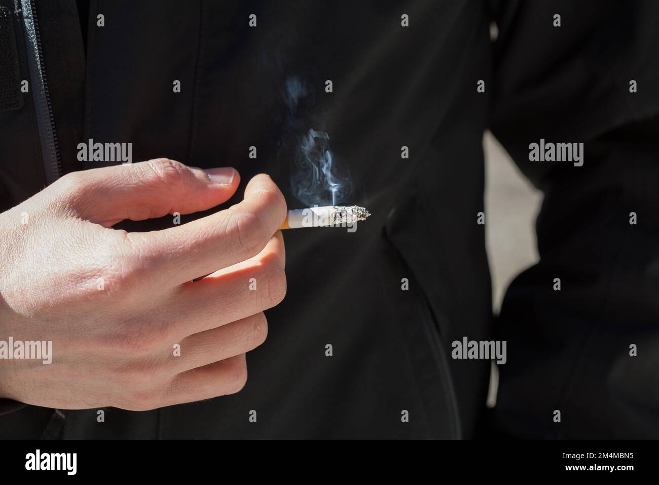 Hand of a heavy smoker with a lit cigarette, concept of tobacco ...