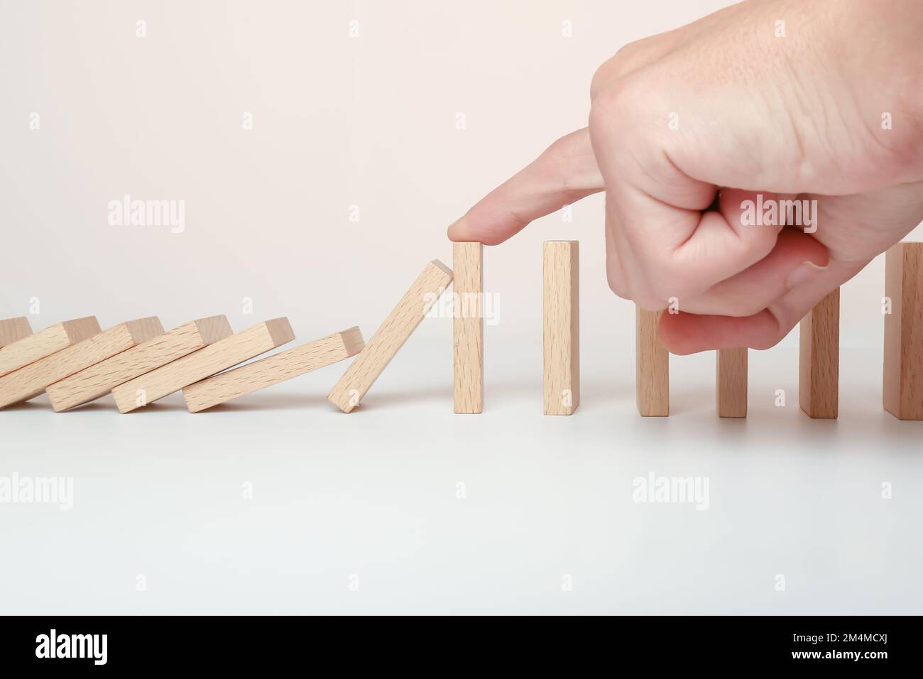 Hand stopping the Domino effect stopped by unique, Business Ideas Stock ...