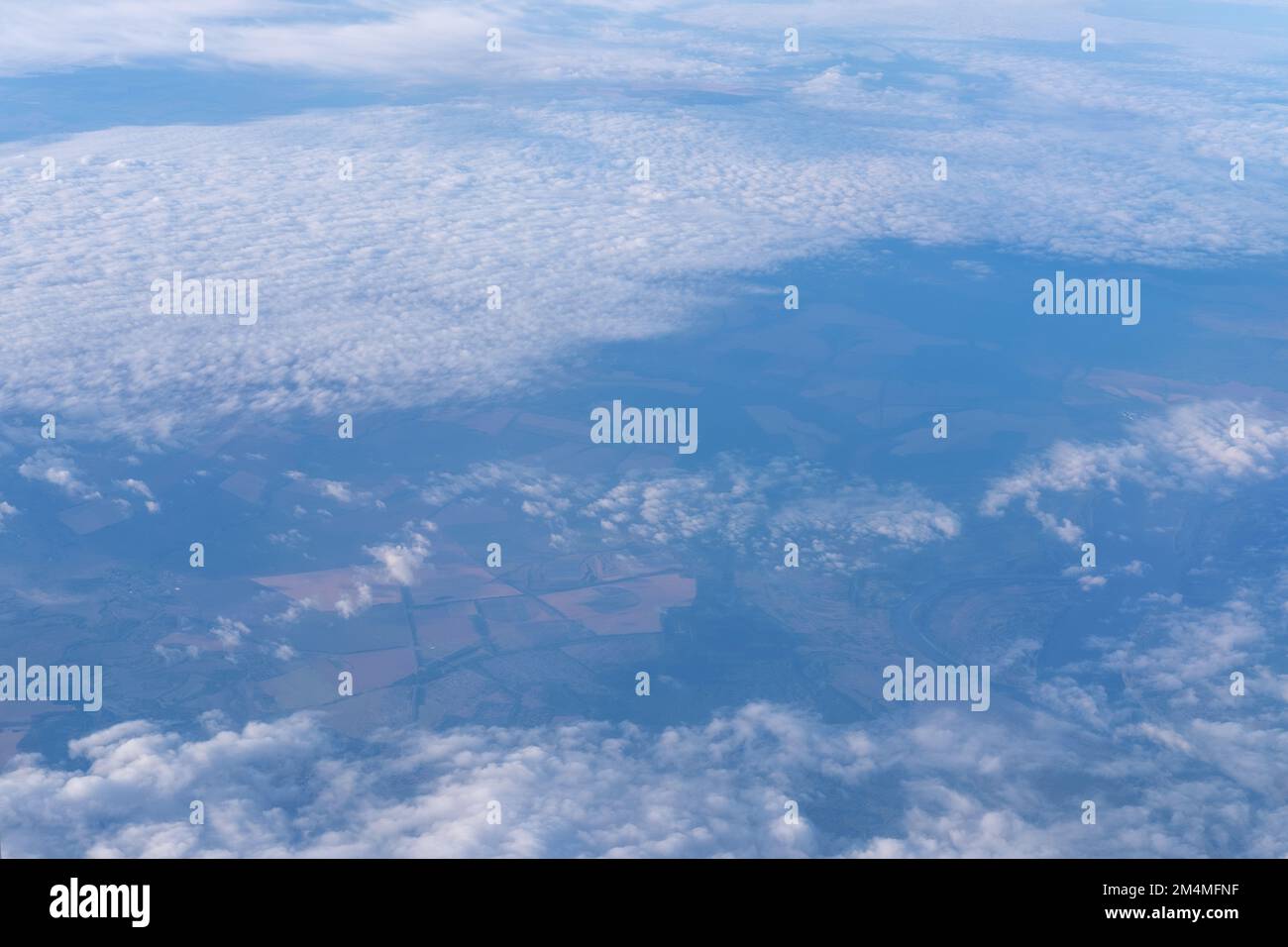 The view from the plane window to the clouds and the ground. The ...