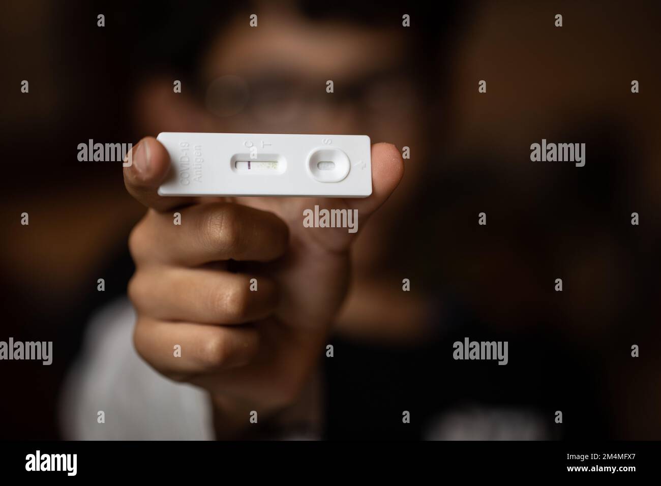 man holding Rapid Antigen Test kit with negative result during swab ...