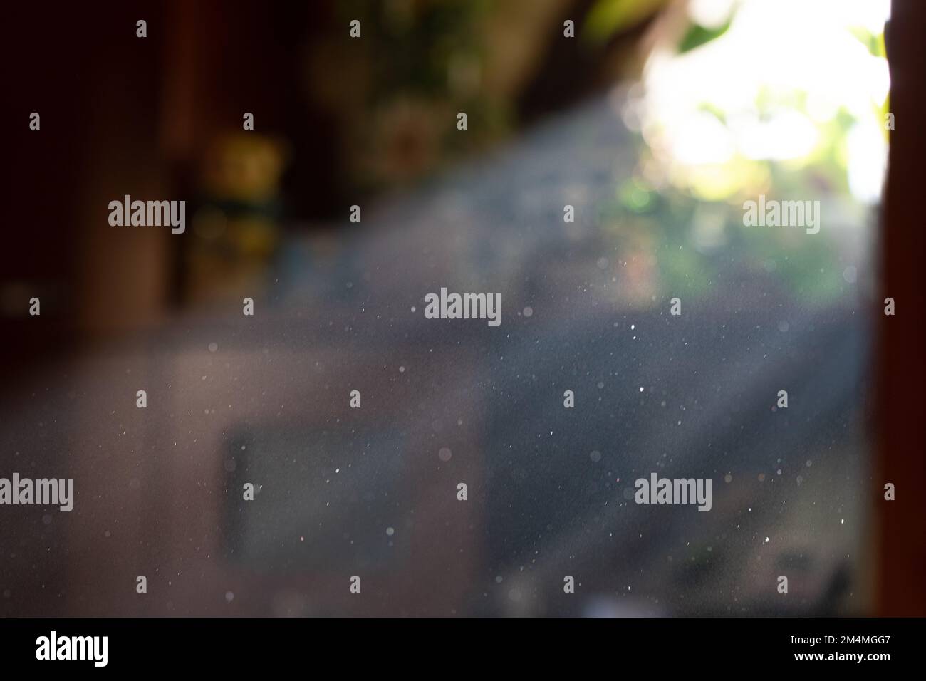 Sun spells by window with bright stream of light and visible particles ...