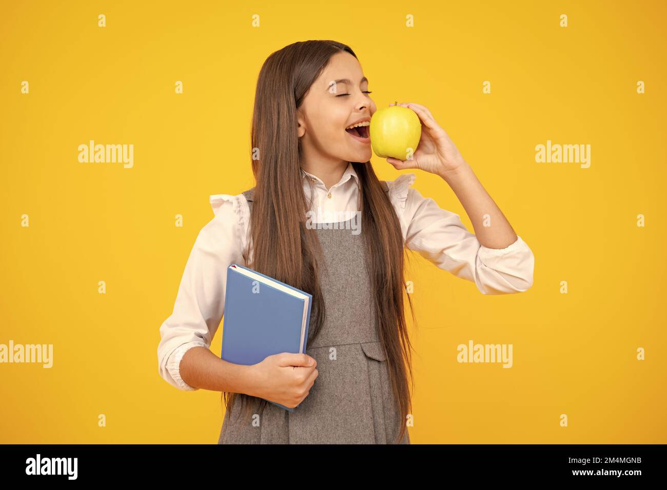Back to school. Schoolgirl student hold book on yellow isolated studio ...