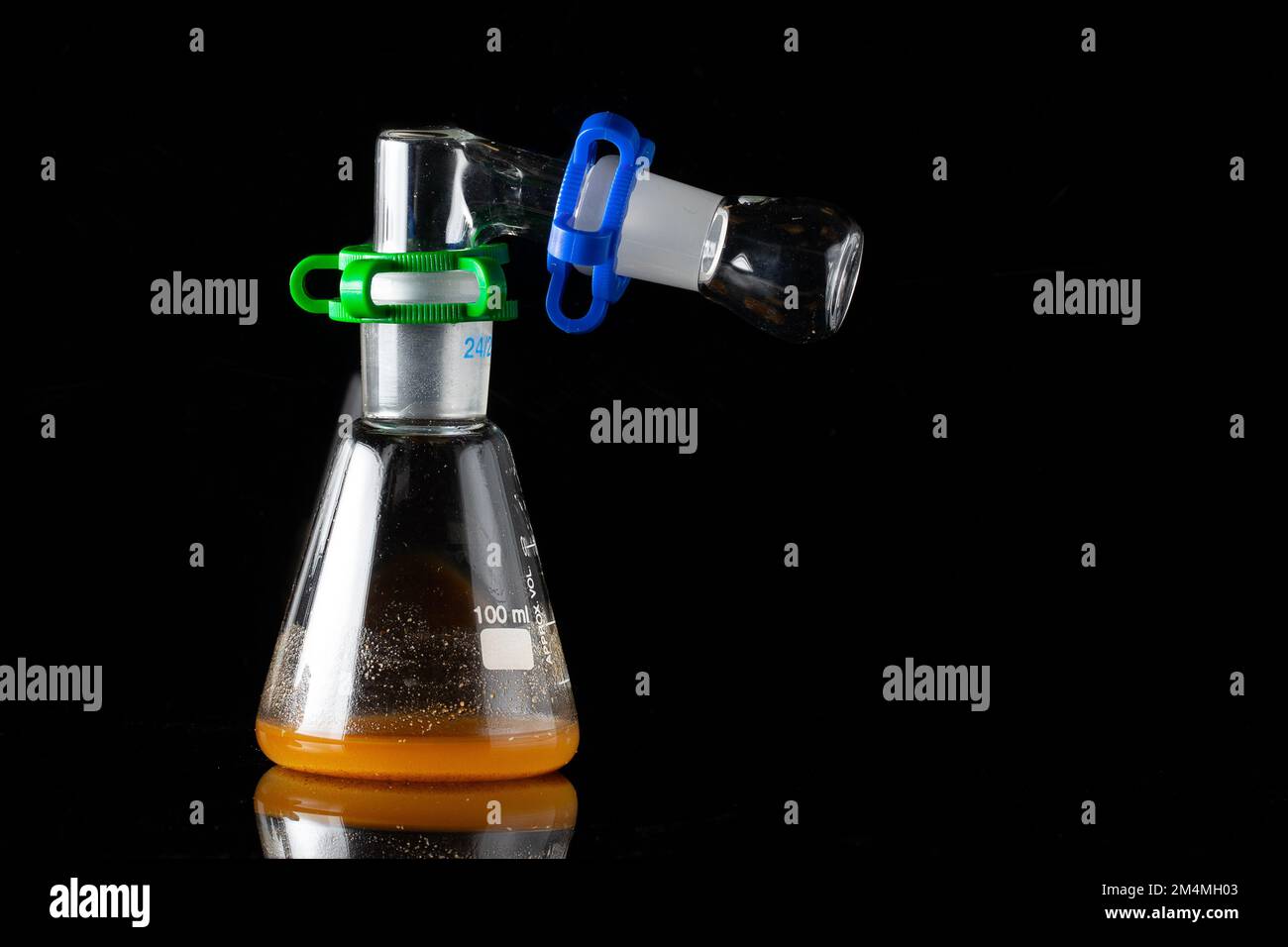 Transparent lab bottle cylinder with orange liquid inside isolated in ...