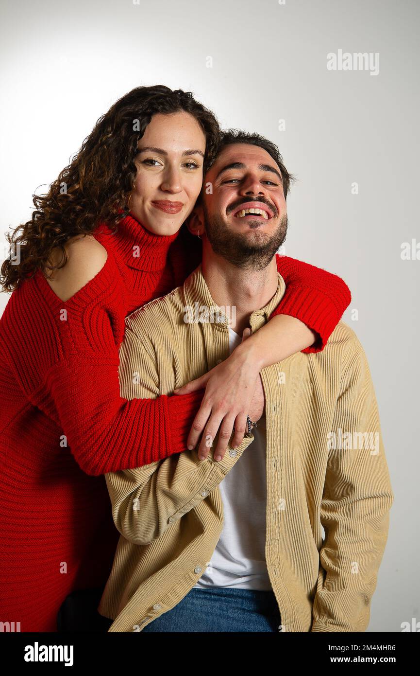 Portrait of happy young couple hugging isolated over gray white ...