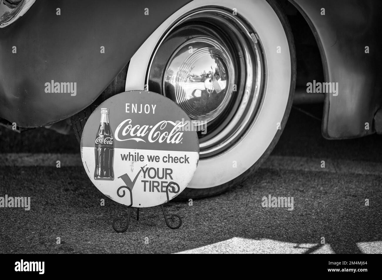 A grayscale shot of Coca-Cola check your tire sign with tire Stock ...