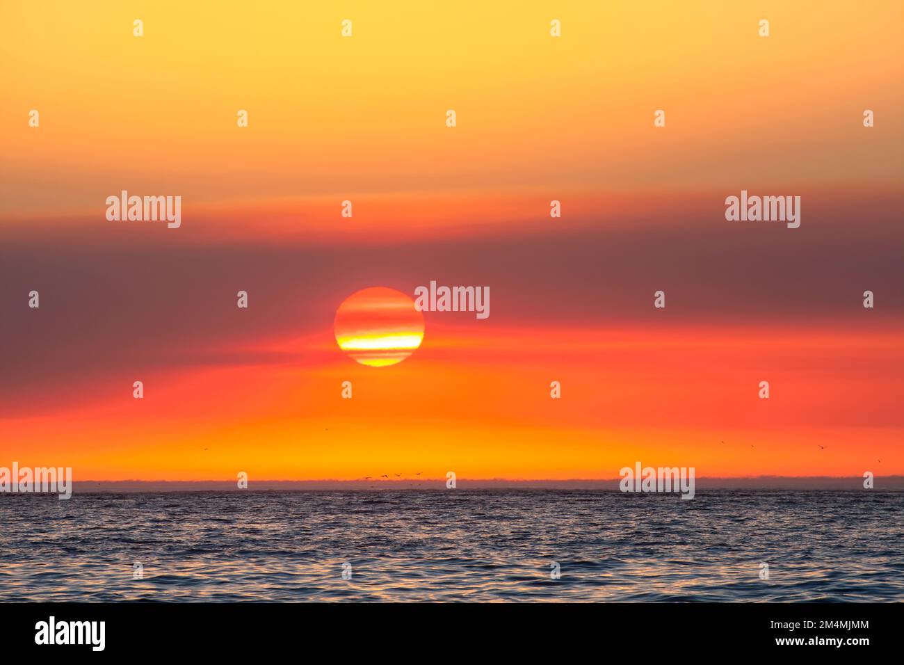 The beautiful orange-shaded sunset sky over the blue seascape Stock ...