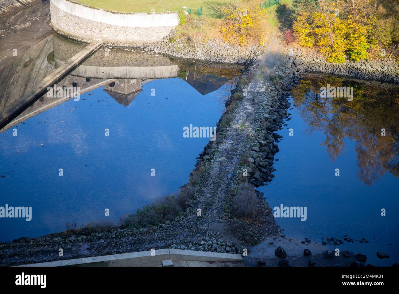 Lake at a dam with plant embankment and tree reflection. High quality ...