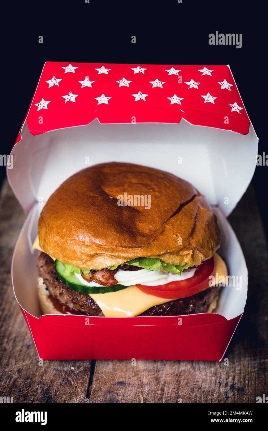 A vertical shot of a burger in a red and white packaging Stock Photo ...