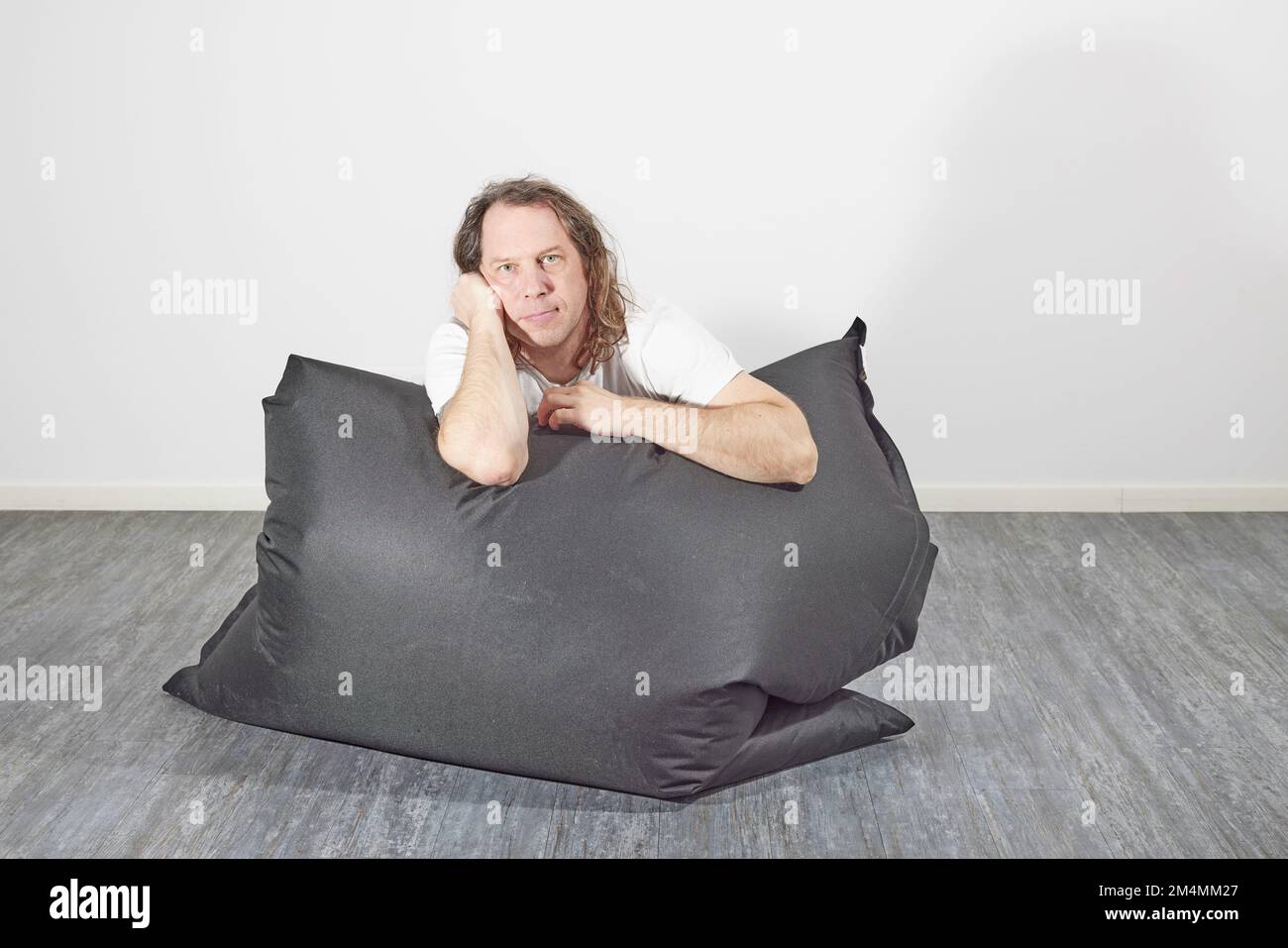 Man on beanbag in relaxing pose Stock Photo - Alamy