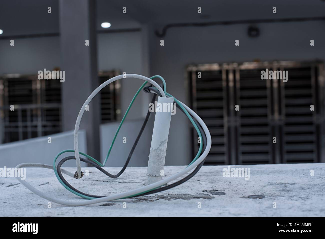 3 electric wires laying out from the concrete wall Stock Photo - Alamy