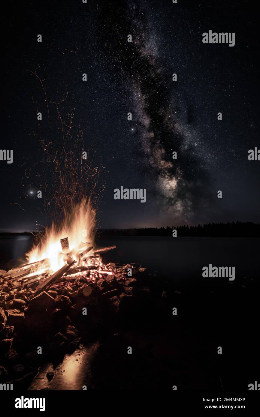 A scenic view of a fire burning under the starry night in Finland Stock ...