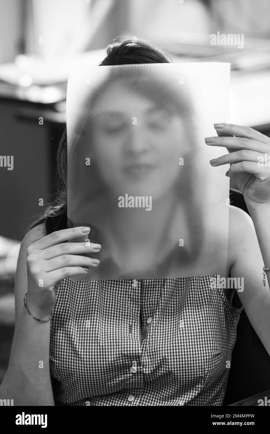 Young woman cover face with plastic sheet paper in public out of ...