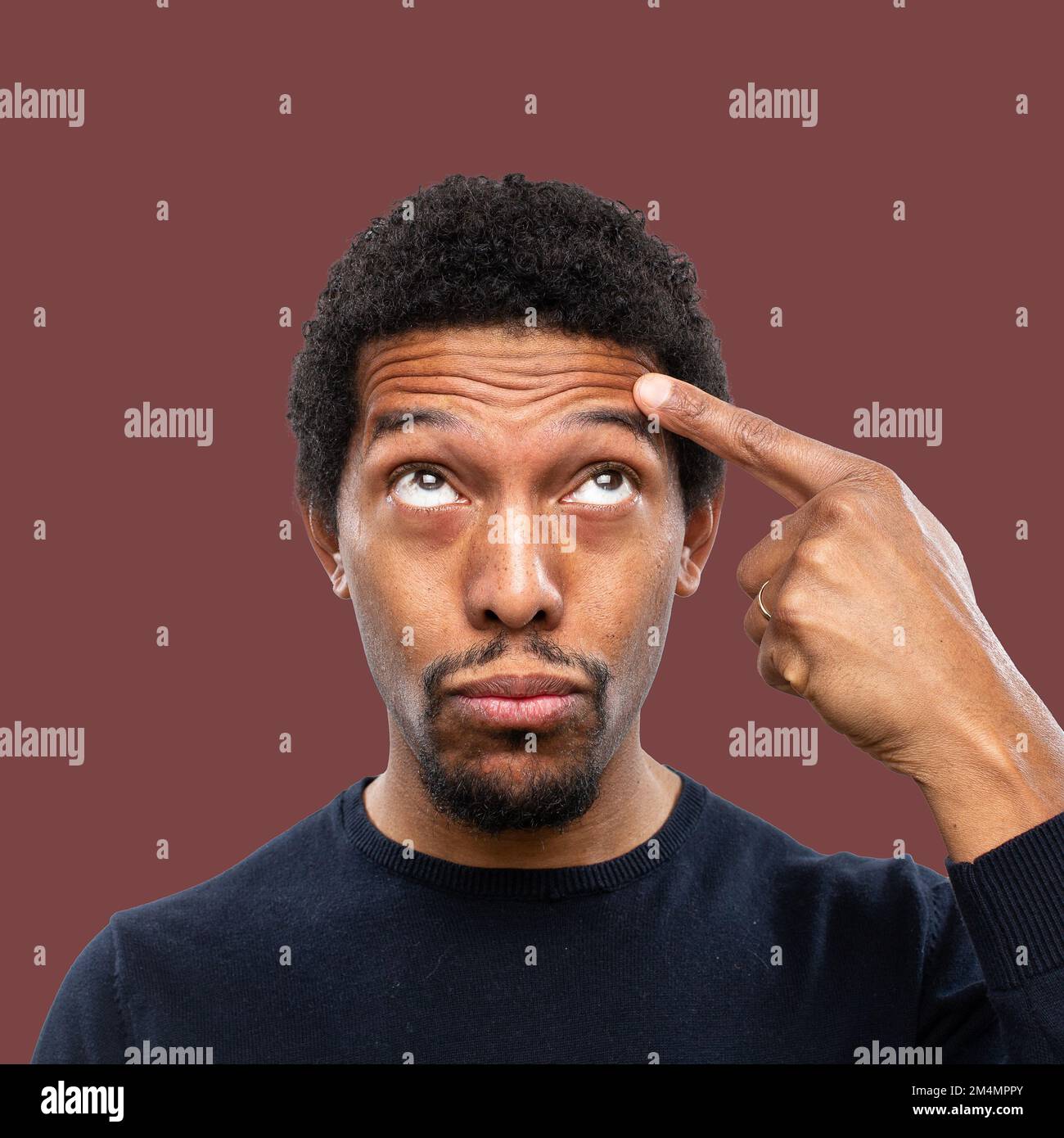 Portrait of African man pointing finger on wrinkles on the forehead ...