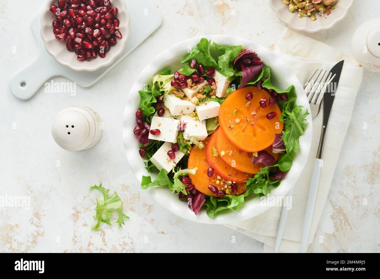 Salad. Fresh green salad with feta cheese, persimmon, pomegranate and ...