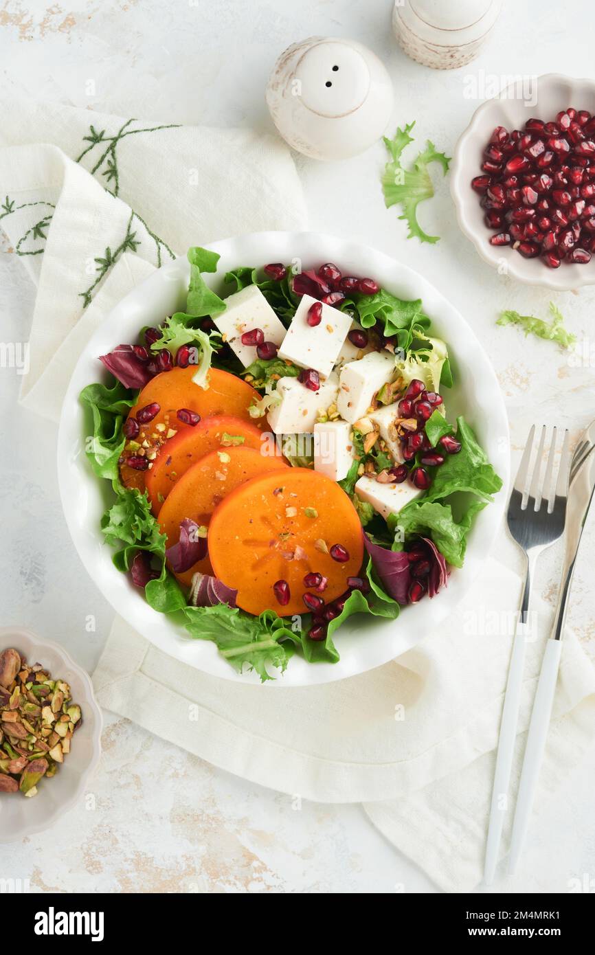 Salad. Fresh green salad with feta cheese, persimmon, pomegranate and ...