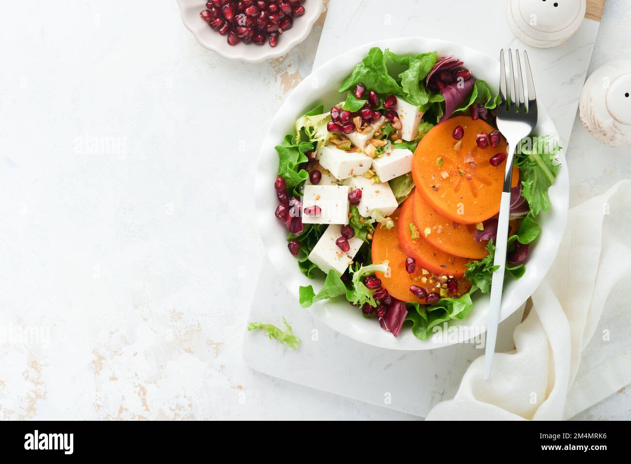 Salad. Fresh green salad with feta cheese, persimmon, pomegranate and ...