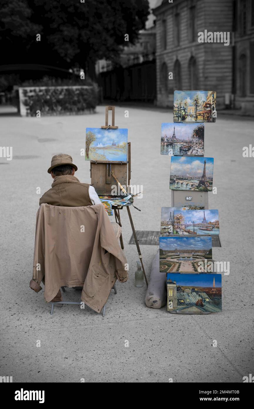 A vertical shot of a French street artist in Versailles, sitting on a ...