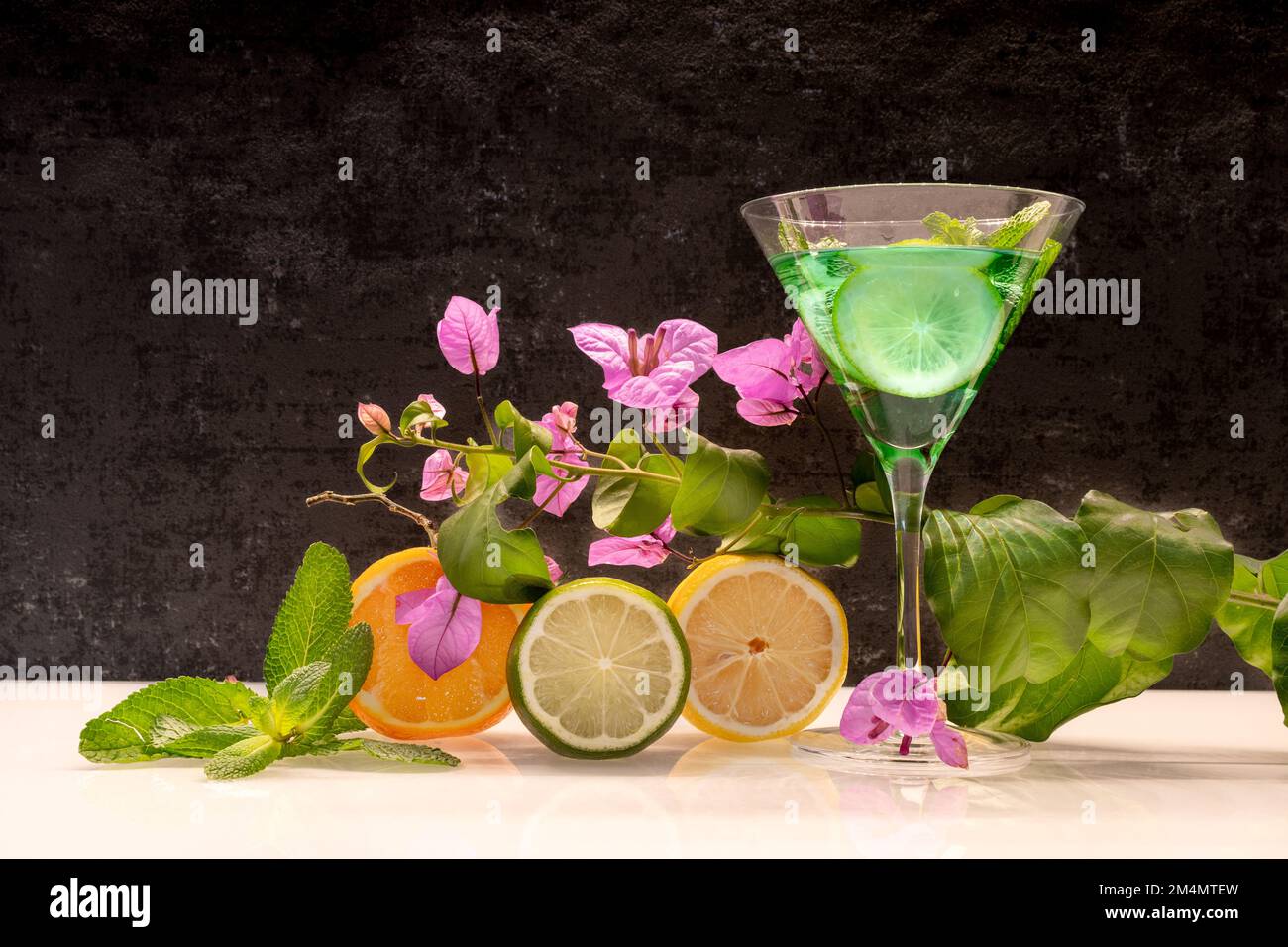 Green cocktail glass with fruits on black background Stock Photo - Alamy