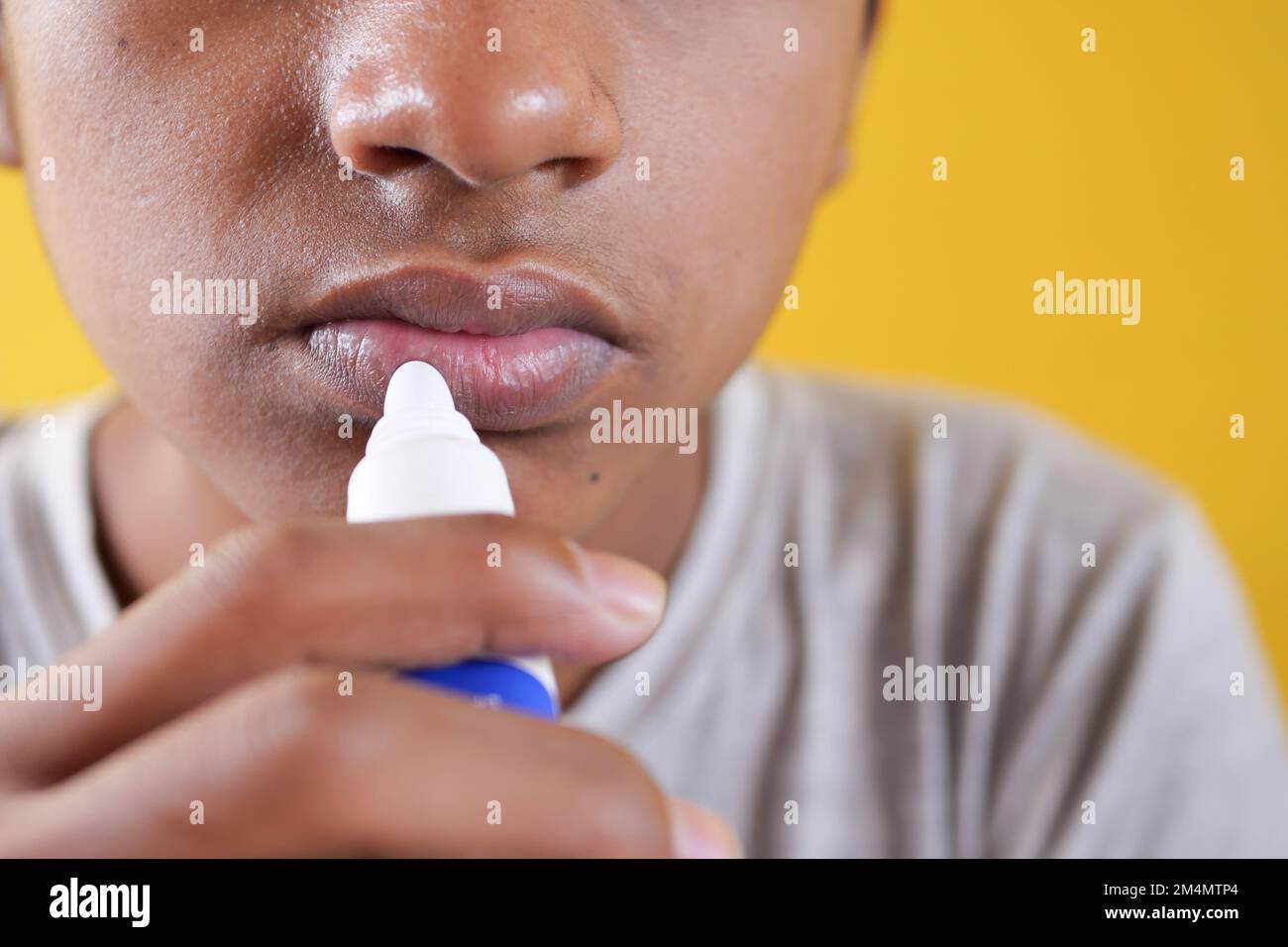 young man applying moisturising lip balm on lips Stock Photo - Alamy