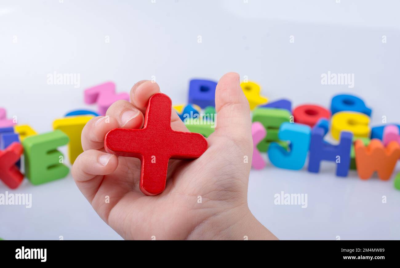 Letter cube of plus sign made of wood Stock Photo - Alamy