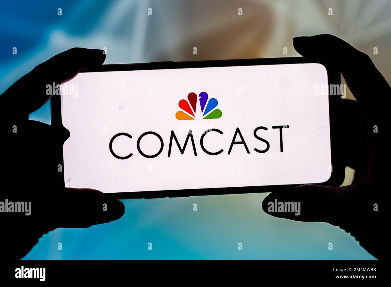 In this photo illustration, a Comcast logo seen displayed on a ...