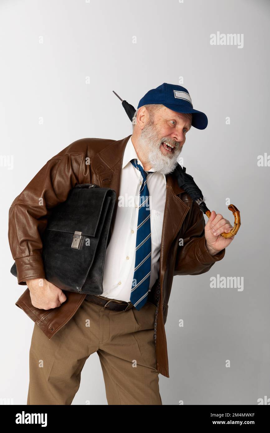 Portrait of senior old man in leather jacket posing with briefcase and ...