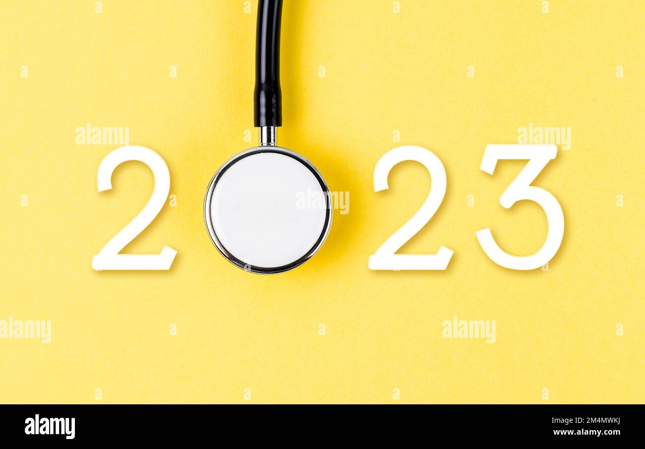 Stethoscope with number 2023 on yellow background. Happy new year for ...
