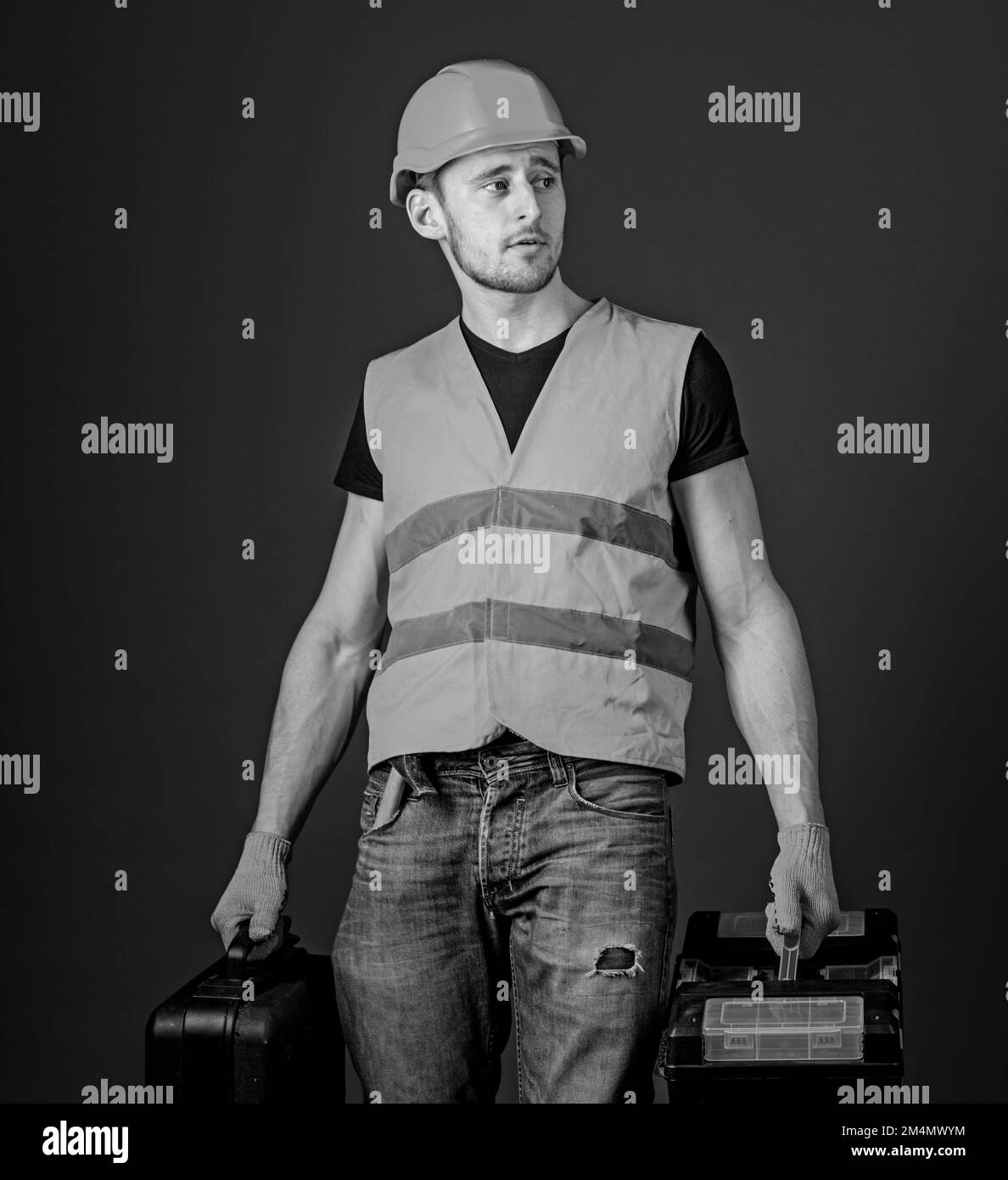 Equipped repairman concept. Man in helmet, hard hat holds toolbox and ...