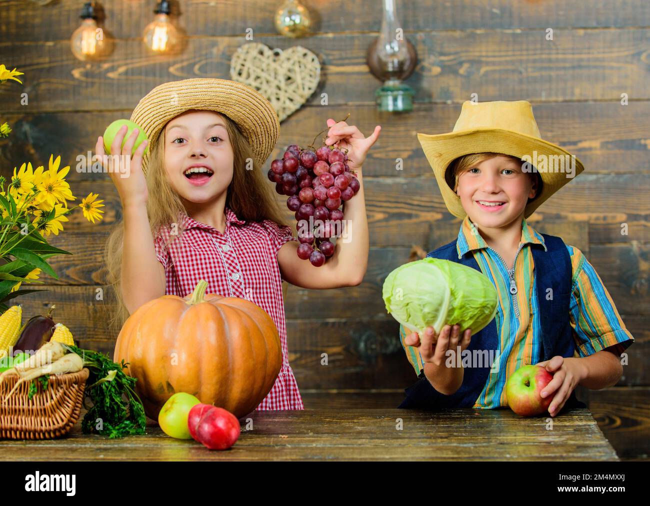 Children near vegetables wooden background. Elementary school fall ...