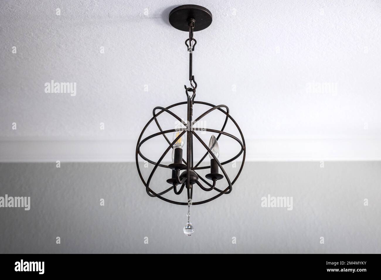 Black hanging sphere modern light fixture Stock Photo - Alamy