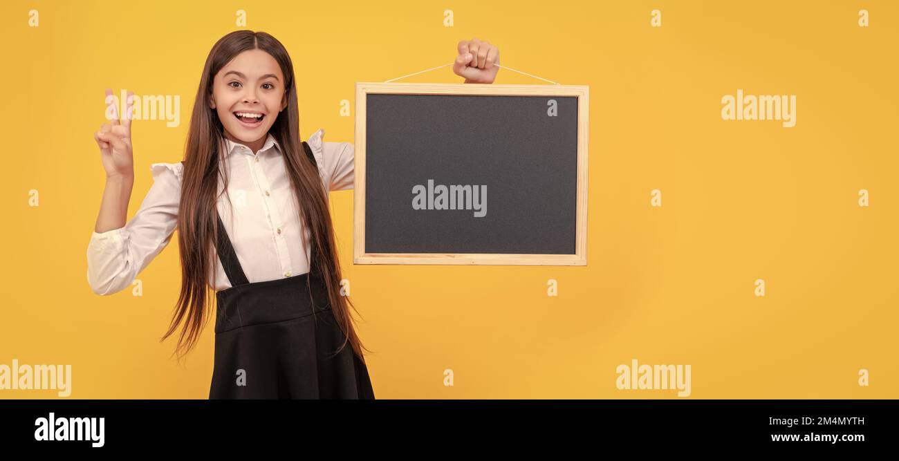 smiling teen girl in uniform hold school blackboard for copy space ...