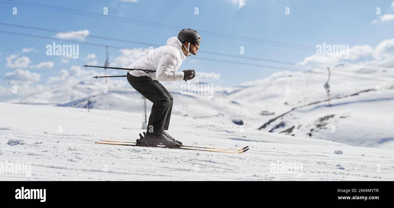 Full length profile shot of a male skier skiing on a mountain Stock ...