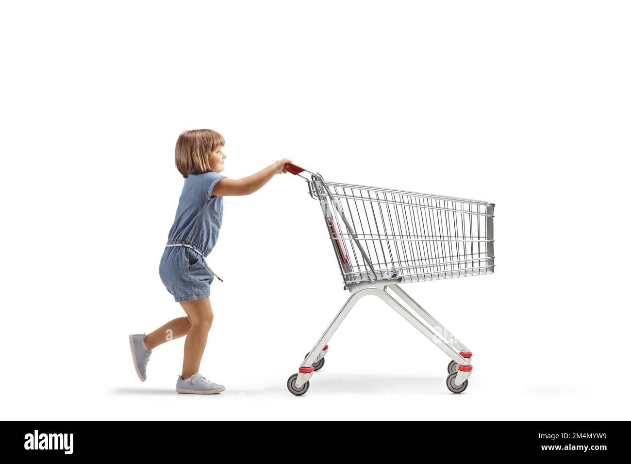 Full length profile shot of a little girl pushing a big empty shopping ...