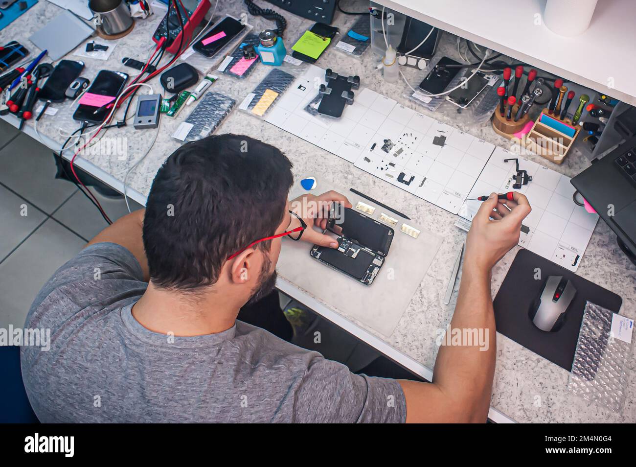 Workplace top view, close-up. Repairman disassembles smartphone with ...