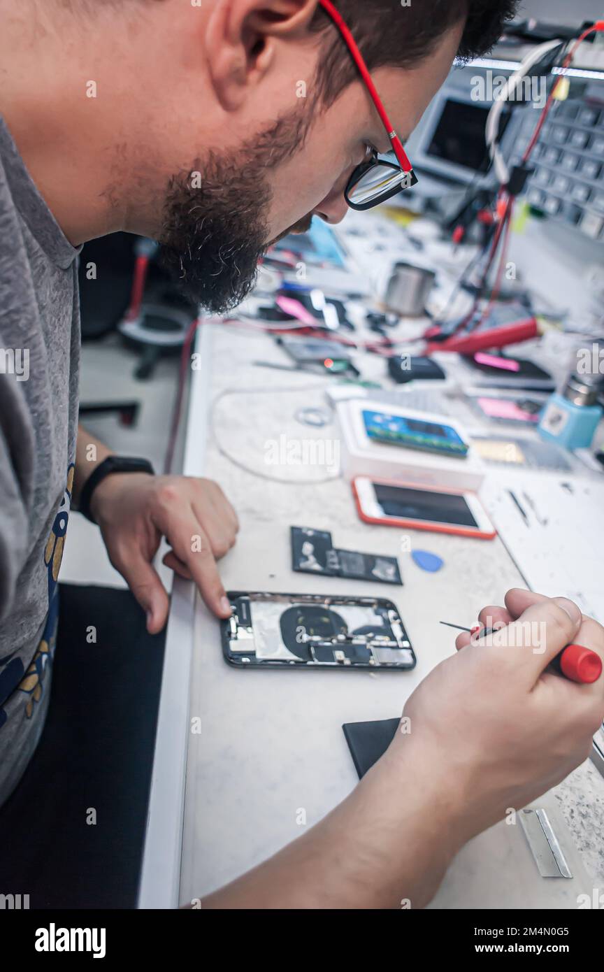 Workplace top view, close-up. Repairman disassembles smartphone with ...