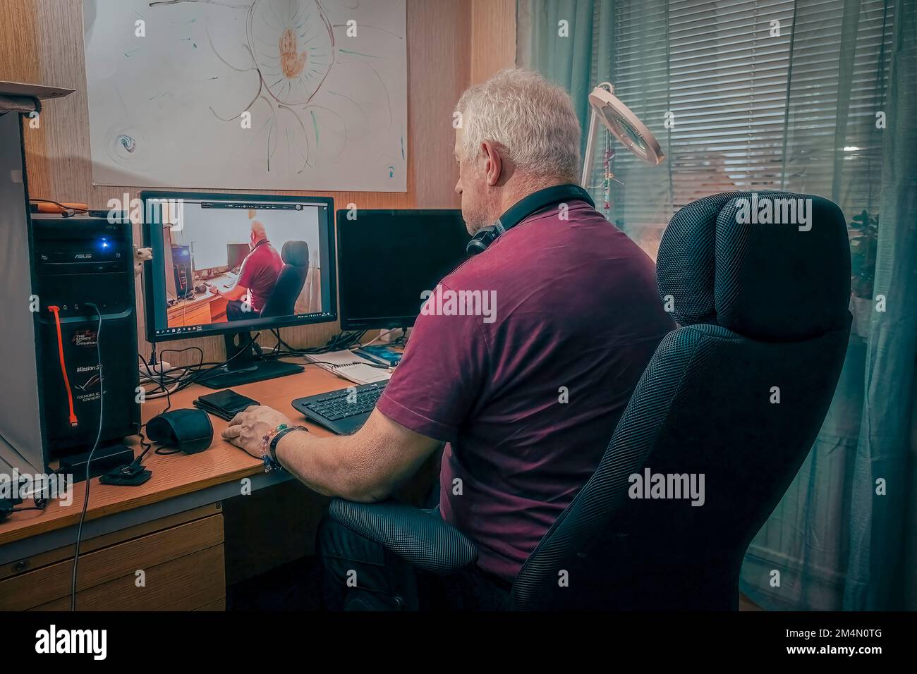 Old senior man in front of his computer with reflextion on the screen ...