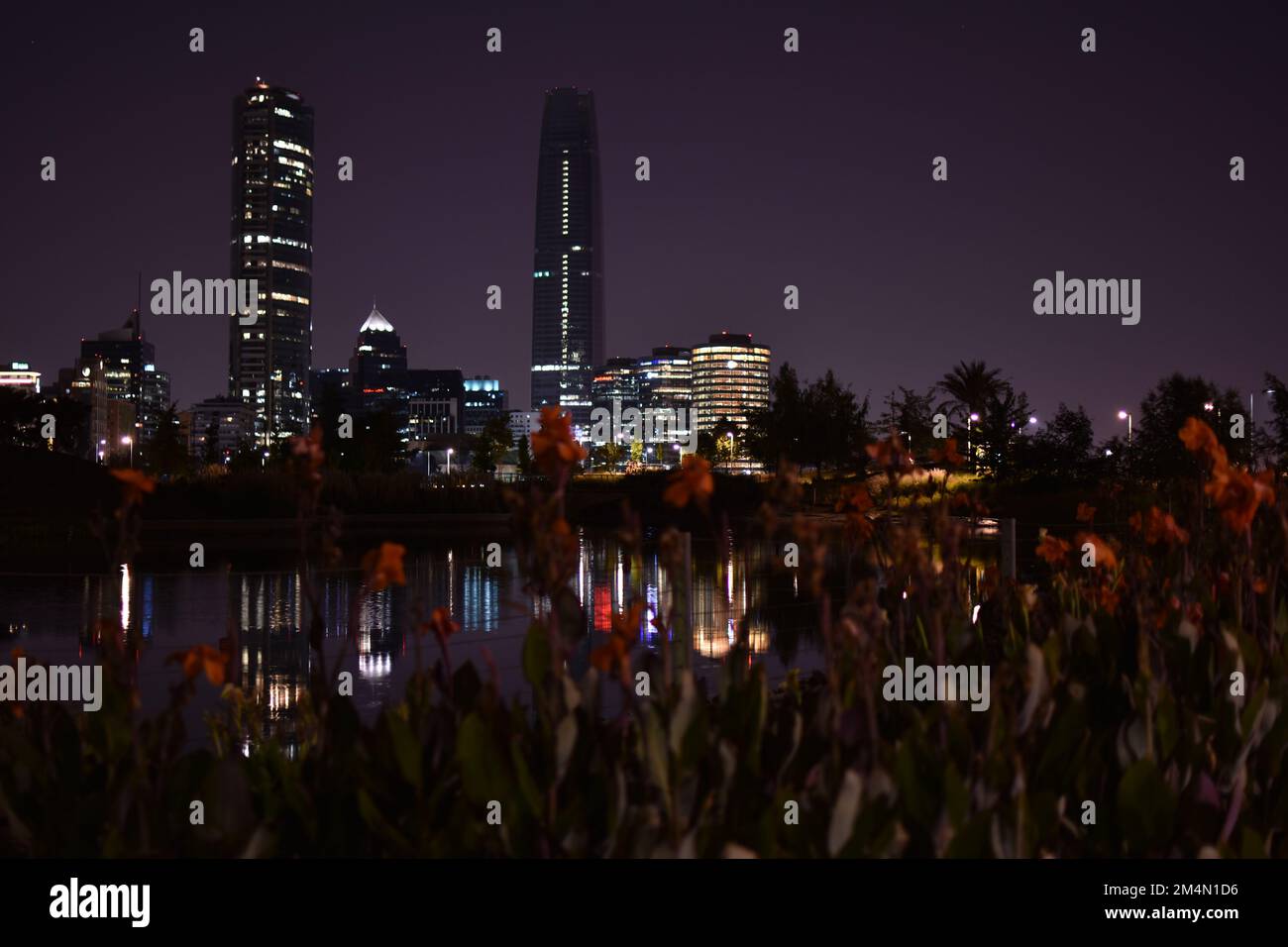 The waterside view of Costanera Center buildings at night Stock Photo ...