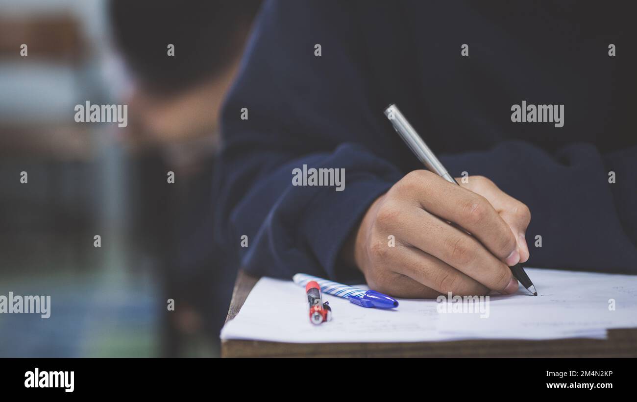 Close up hand of students reading and taking exam sheets exercises ...