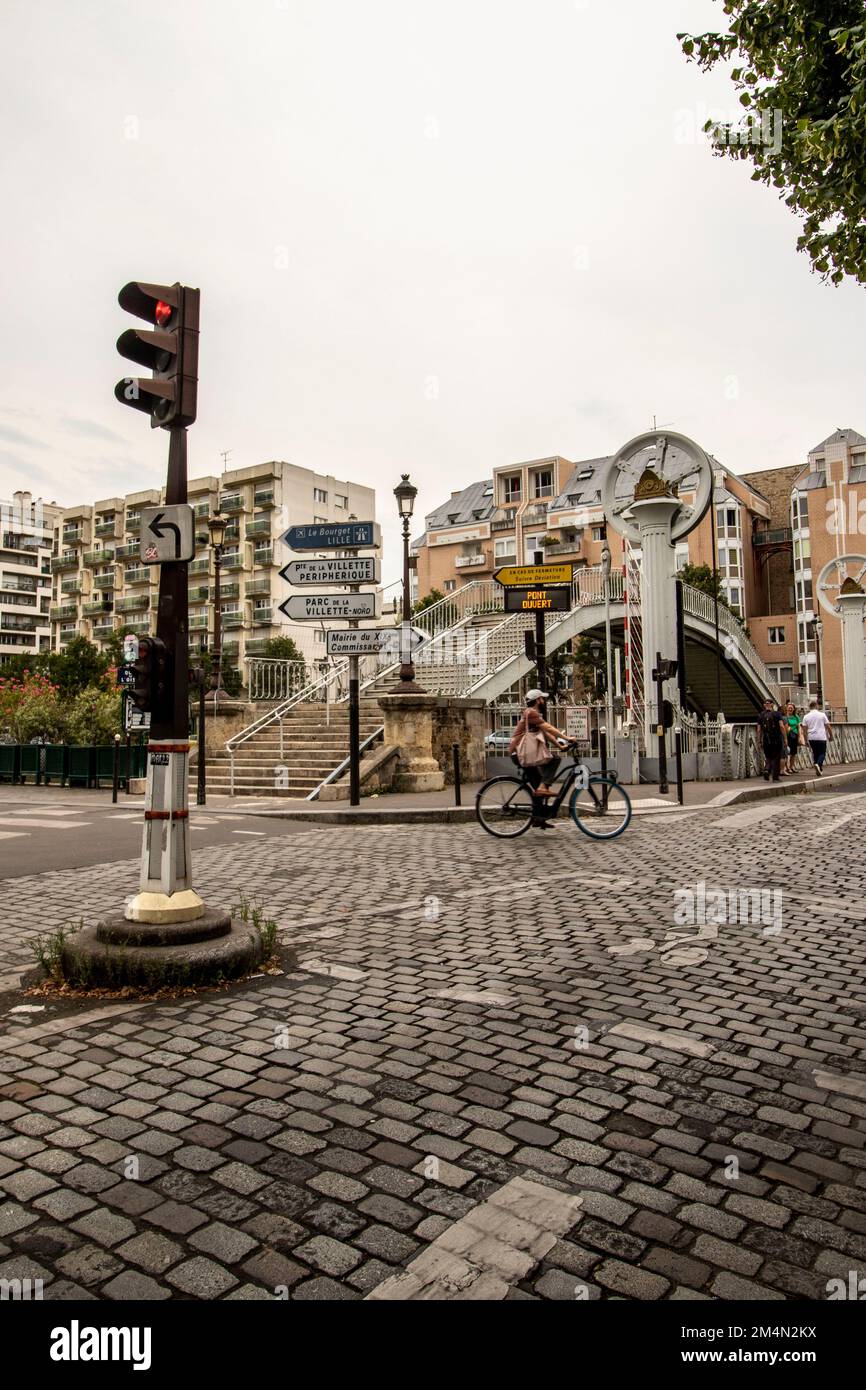 Paris cobbled street with the The Pont de Flandre, metal lift bridge ...