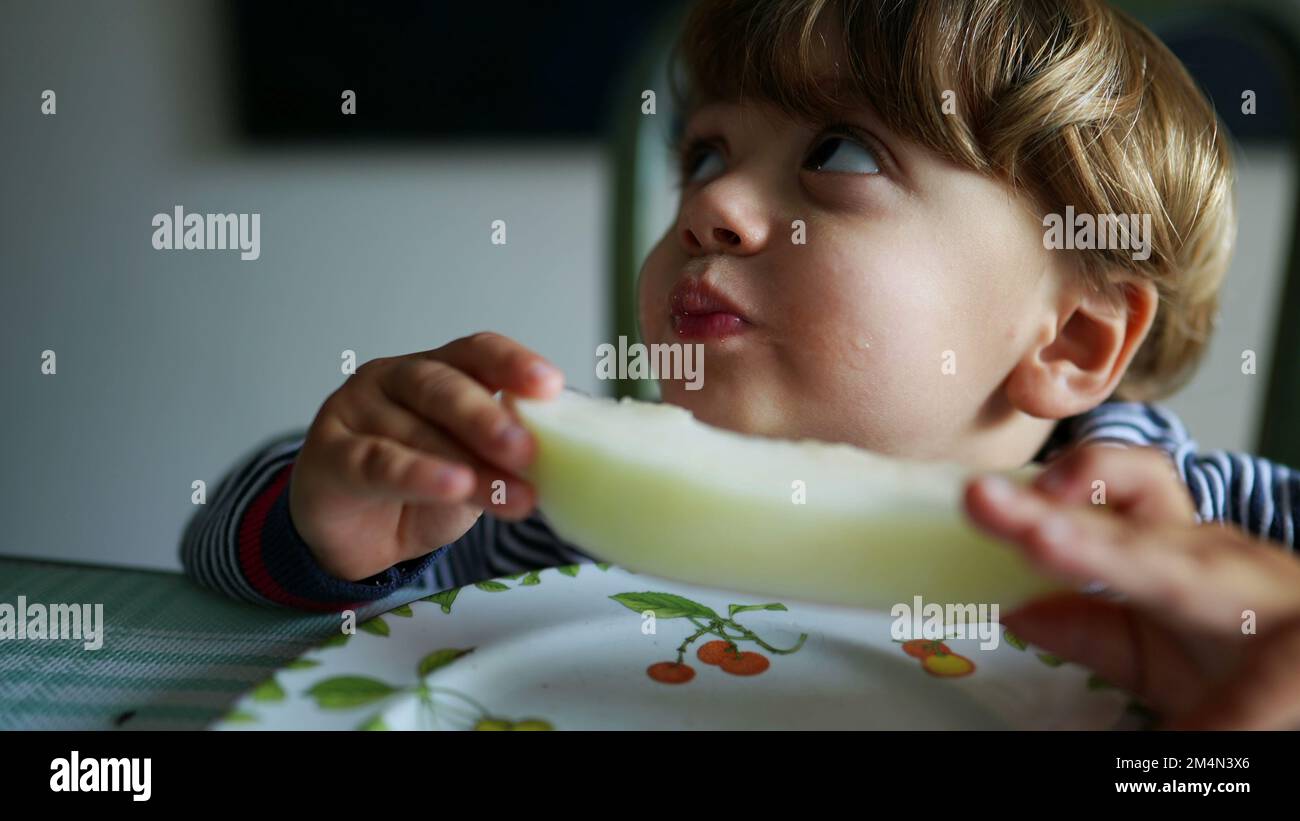 Child eating melon fruit hungry little boy eats healthy snack Stock ...