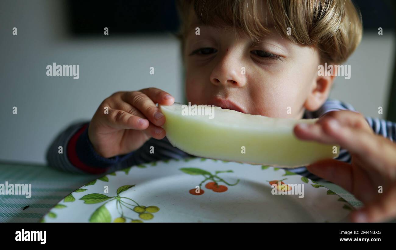 Child eating melon fruit hungry little boy eats healthy snack Stock ...